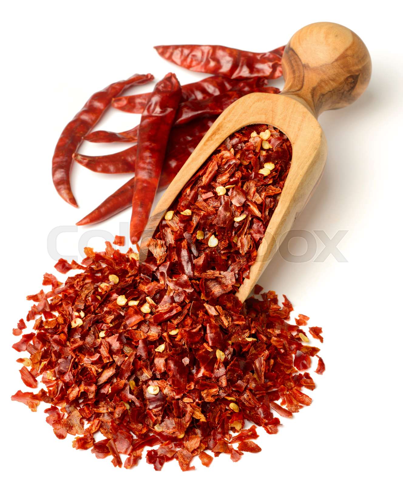 dried red pepper flakes in the olive wooden scoop, isolated on white ...