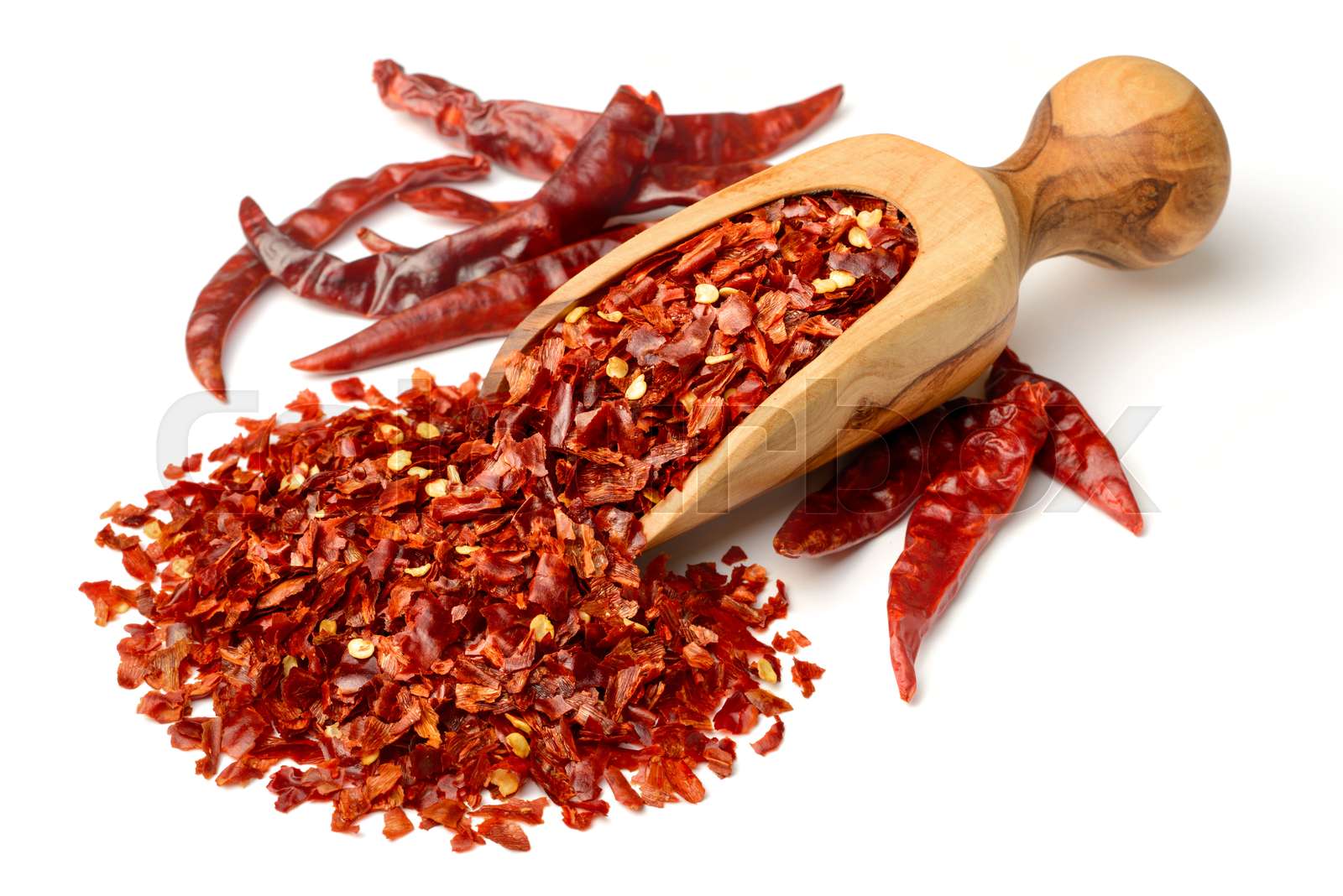dried red pepper flakes in the olive wooden scoop, isolated on white ...