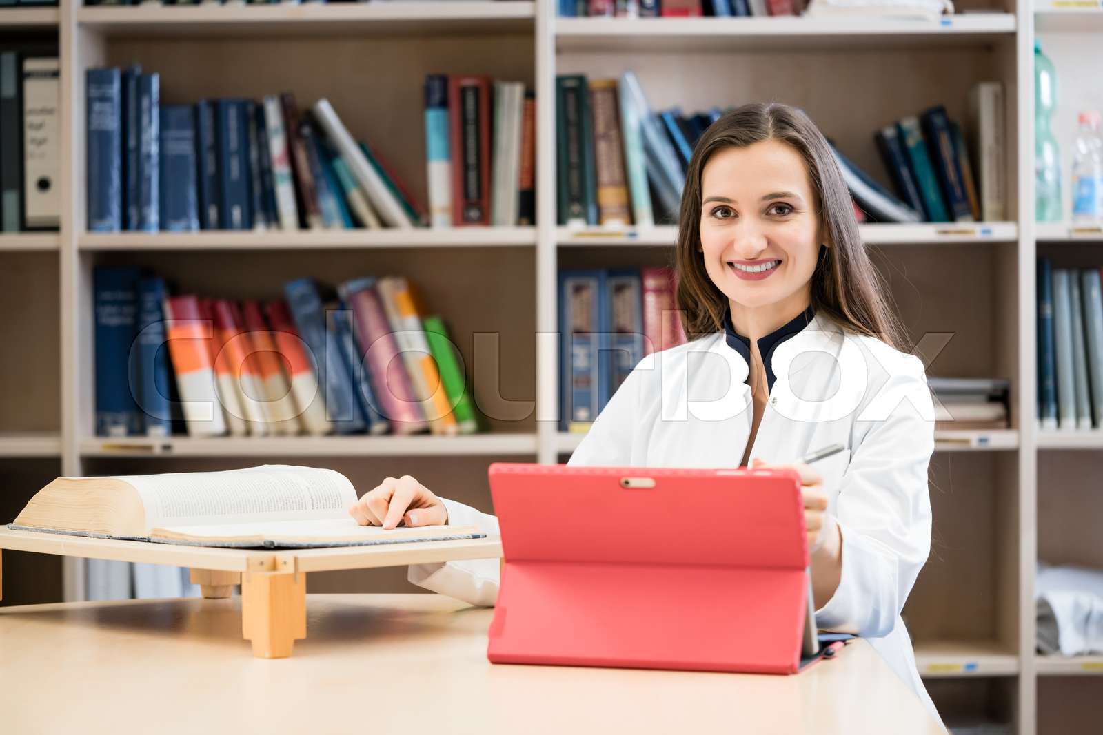 Medical student in library researching books | Stock image | Colourbox