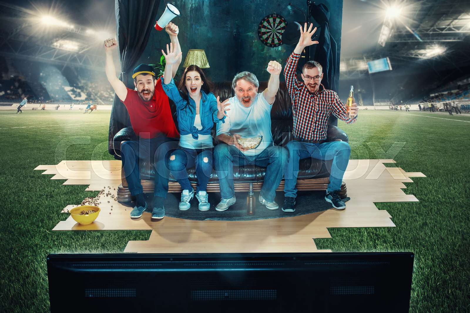 Soccer football fans sitting on the sofa and watching TV in the middle ...