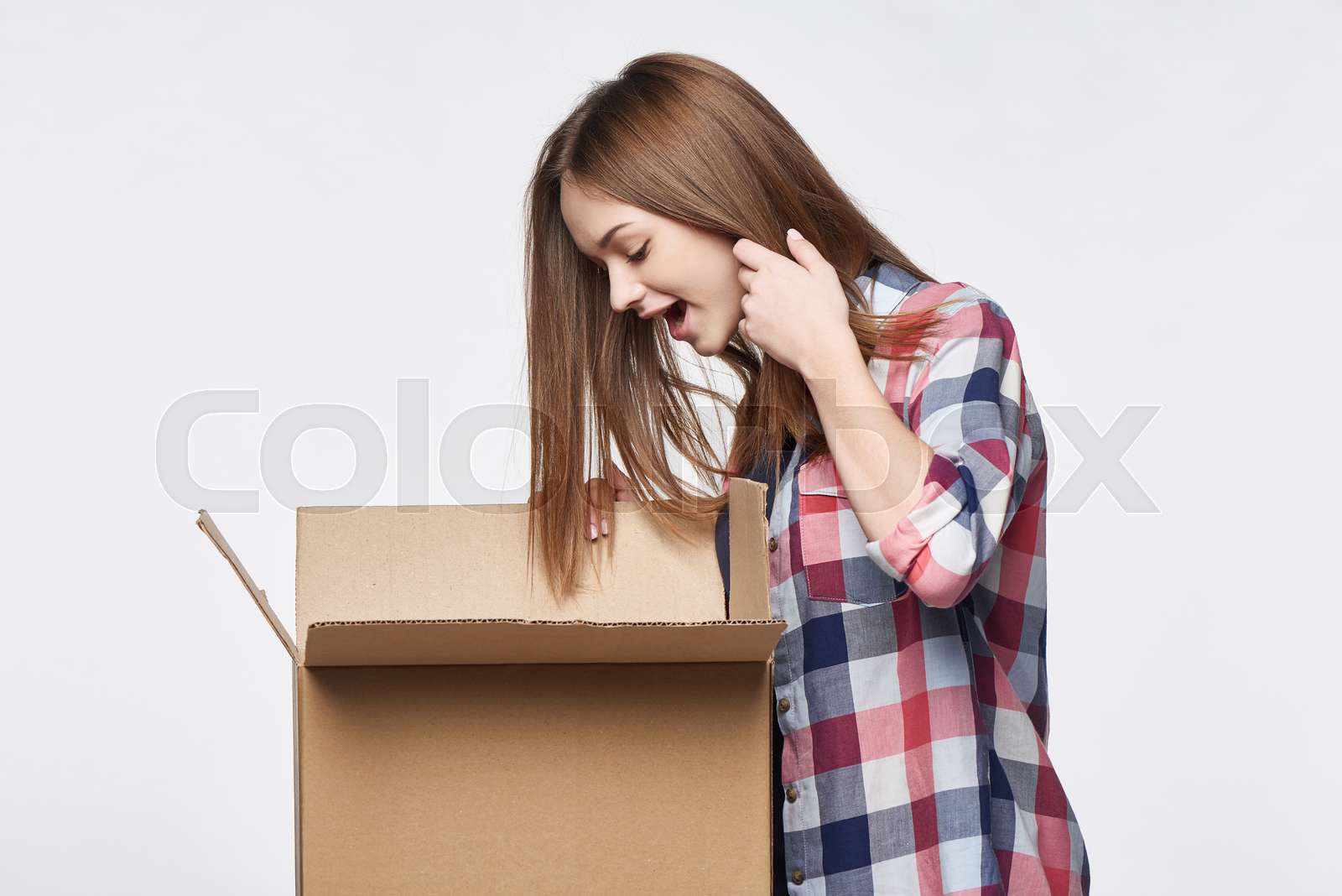 Side view a girl opening a box | Stock image | Colourbox