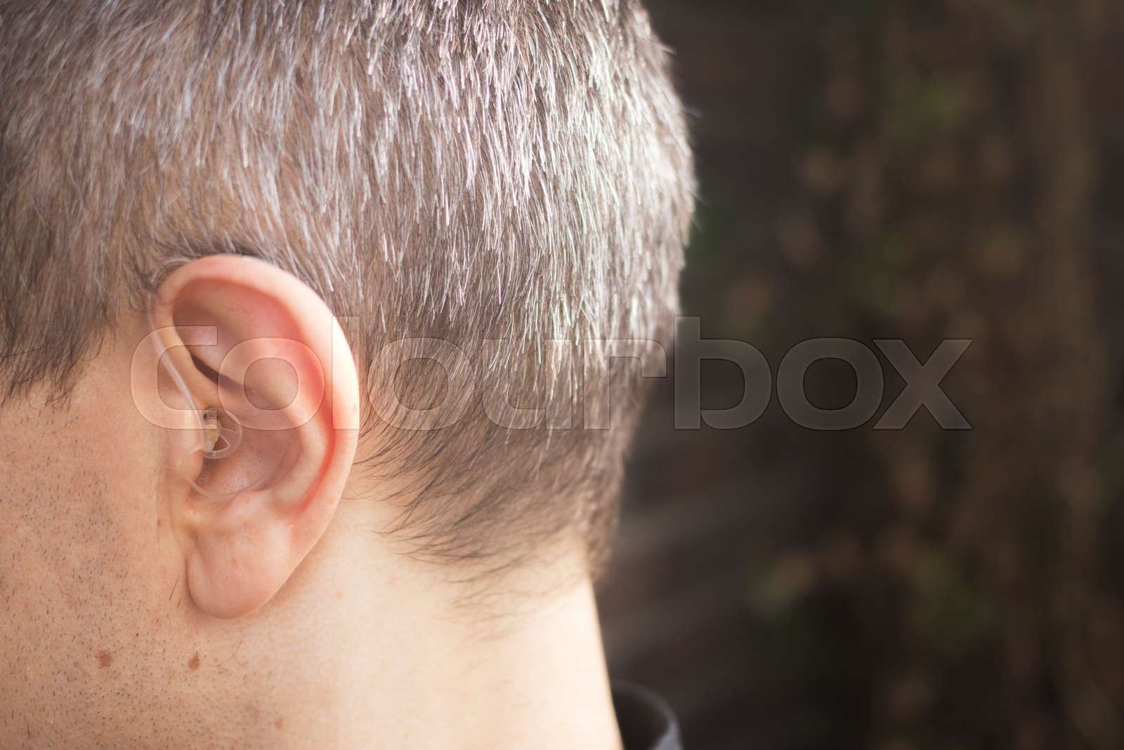 Deaf man hearing aid ear | Stock image | Colourbox