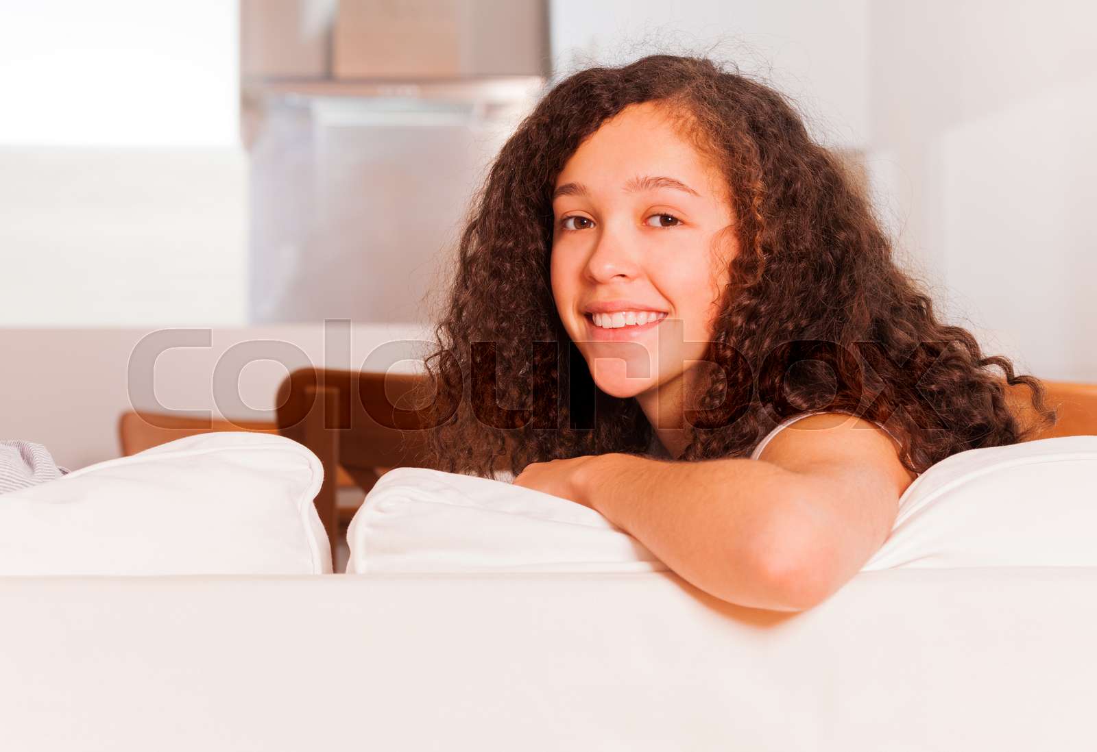 Beautiful girl turned backwards on white sofa | Stock image | Colourbox