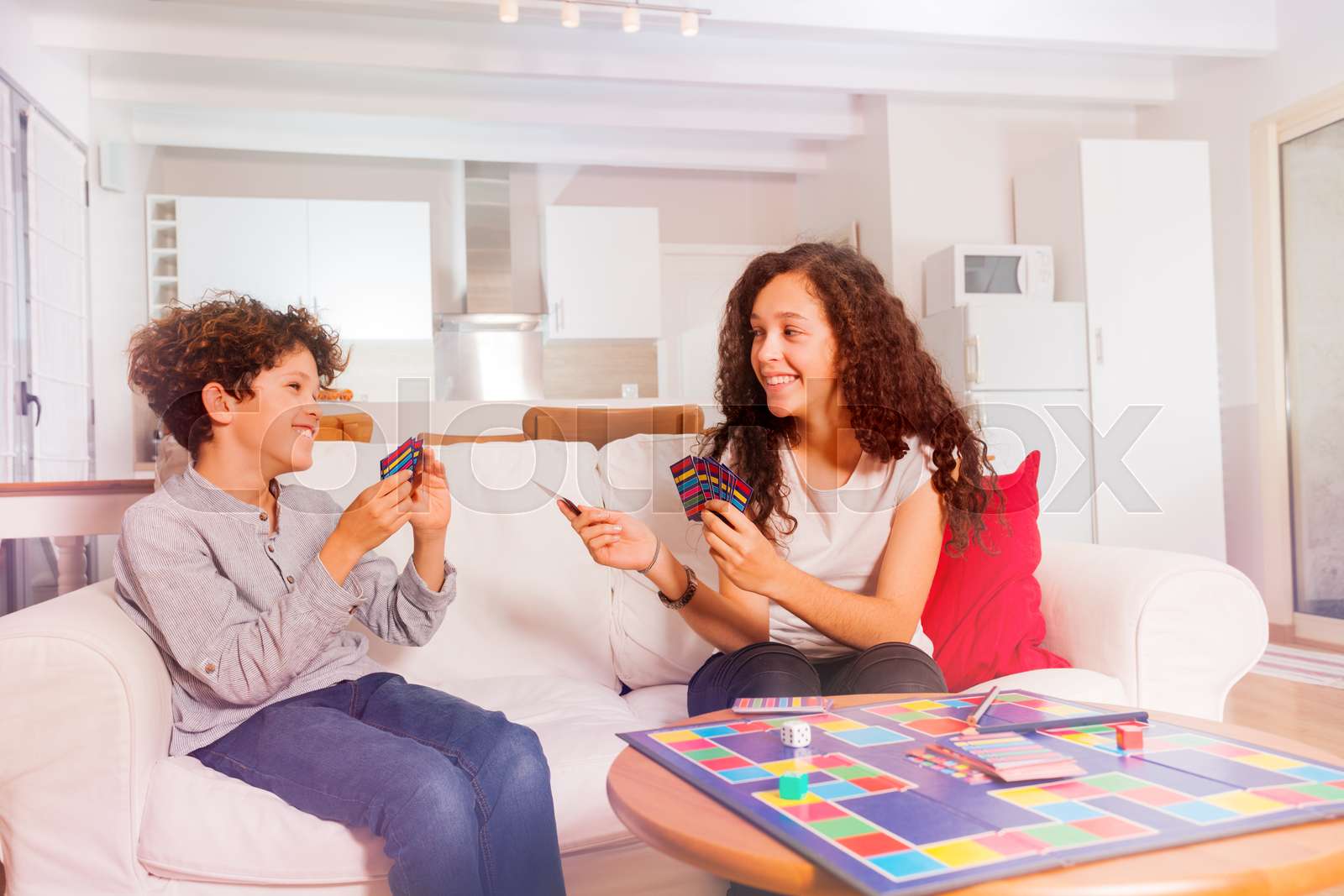 Brother and sister having fun playing card games | Stock image | Colourbox