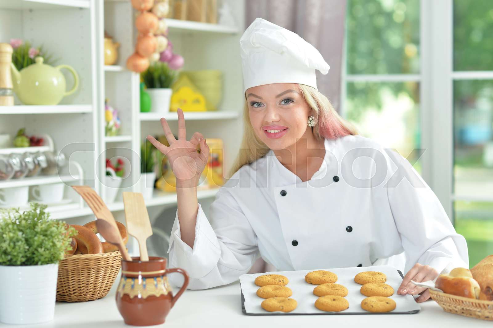 Beautiful young woman in chefs hat preparing delicious cookies | Stock ...