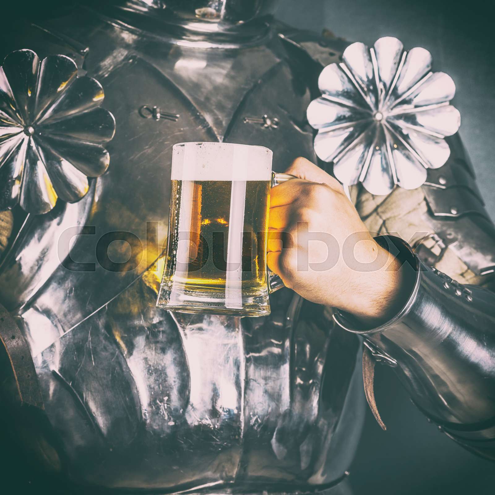 knight wearing armor and holding mug of beer | Stock image | Colourbox