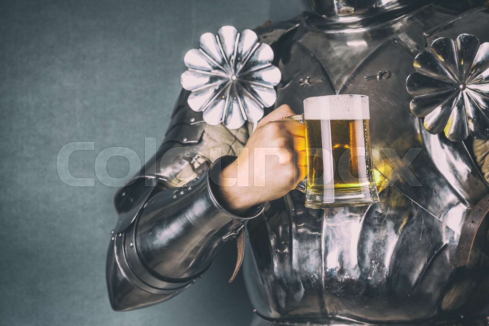 knight wearing armor and holding mug of beer | Stock image | Colourbox