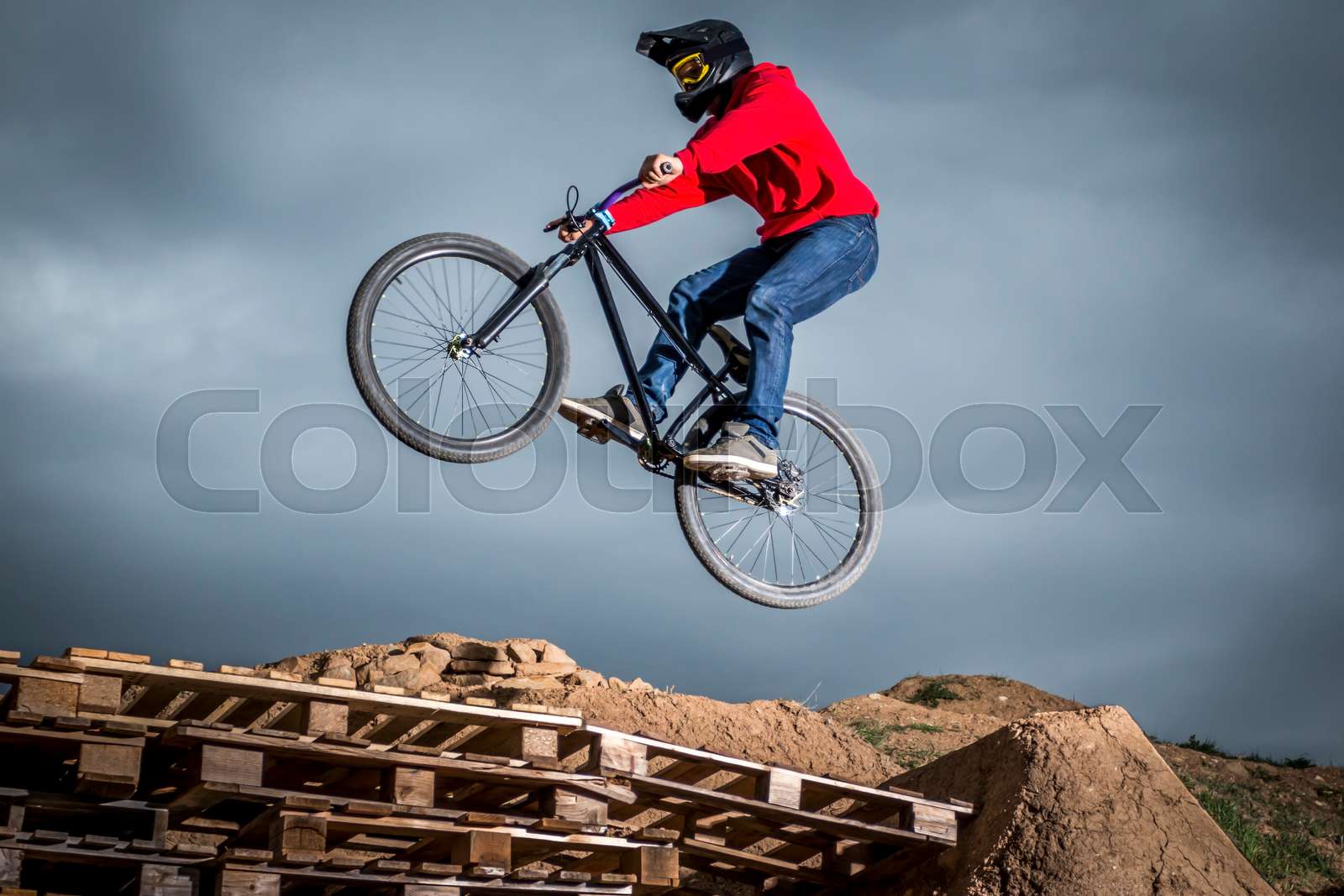 Young man jumping over hole in dirtjump circuit | Stock image | Colourbox
