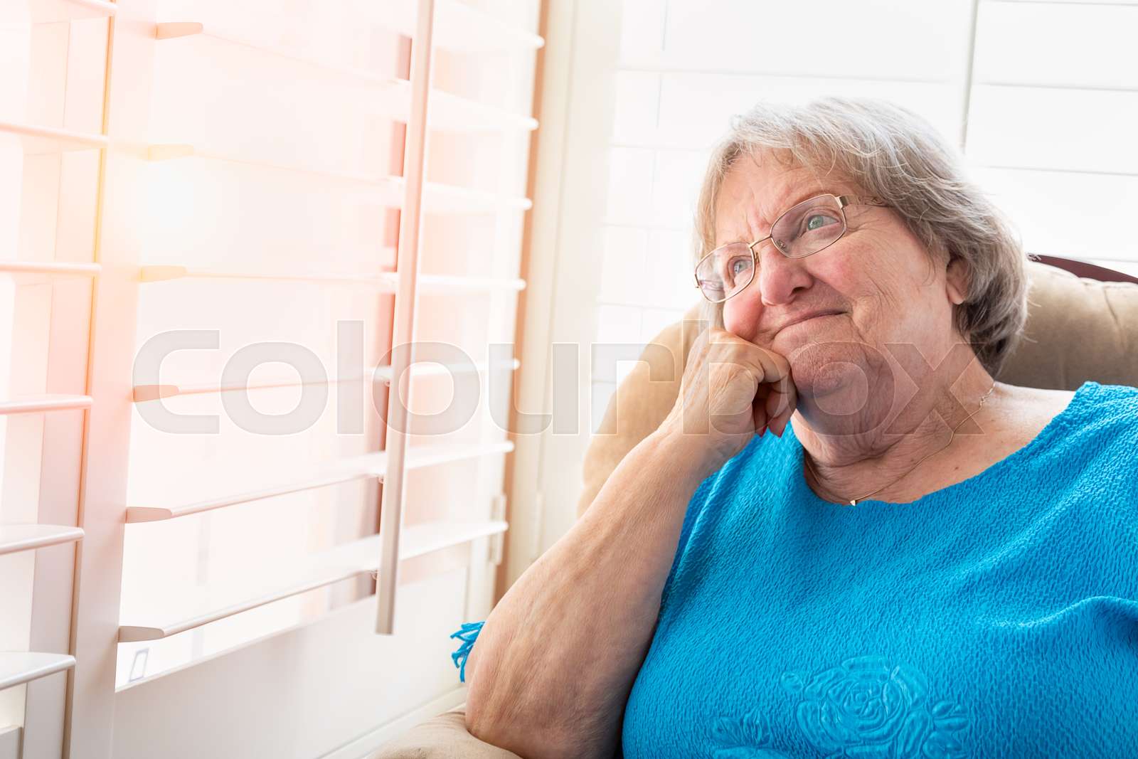 Content Senior Woman Gazing Out of Her Window | Stock image | Colourbox