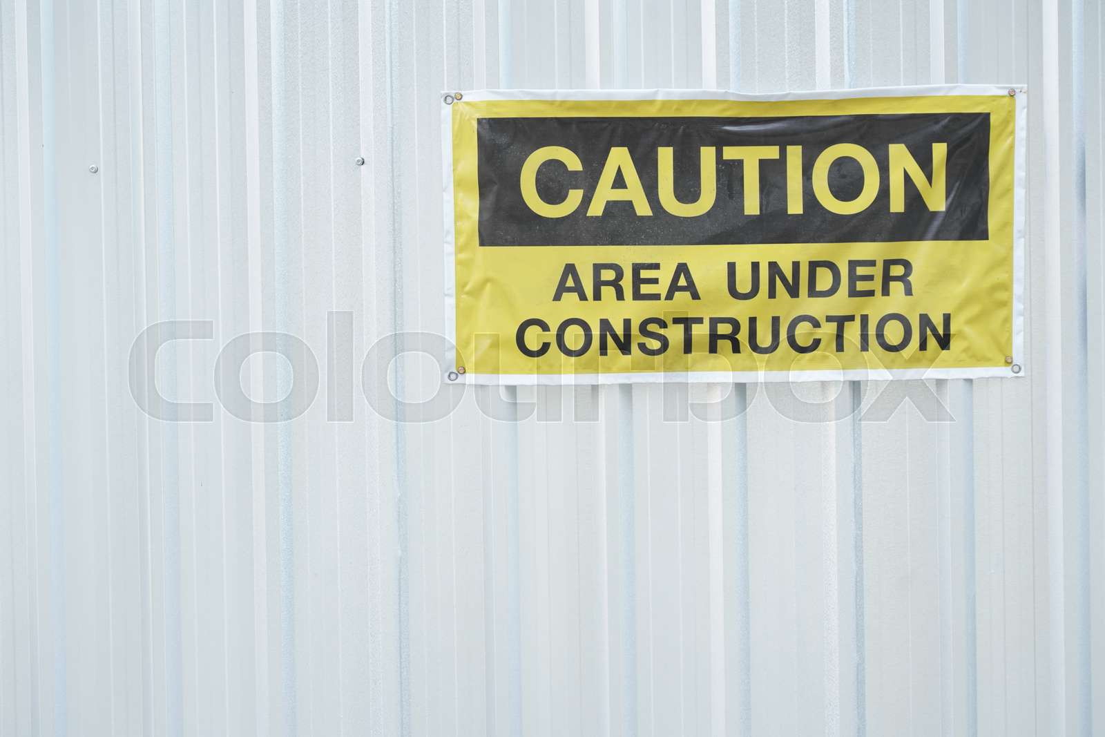 caution construction area sign on the metal wall | Stock image | Colourbox