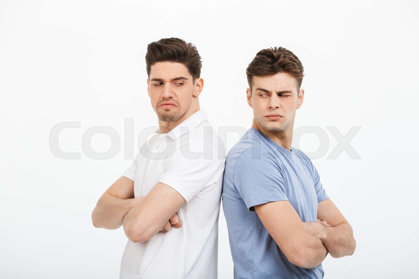 Portrait of two upset young men standing back to back | Stock image ...