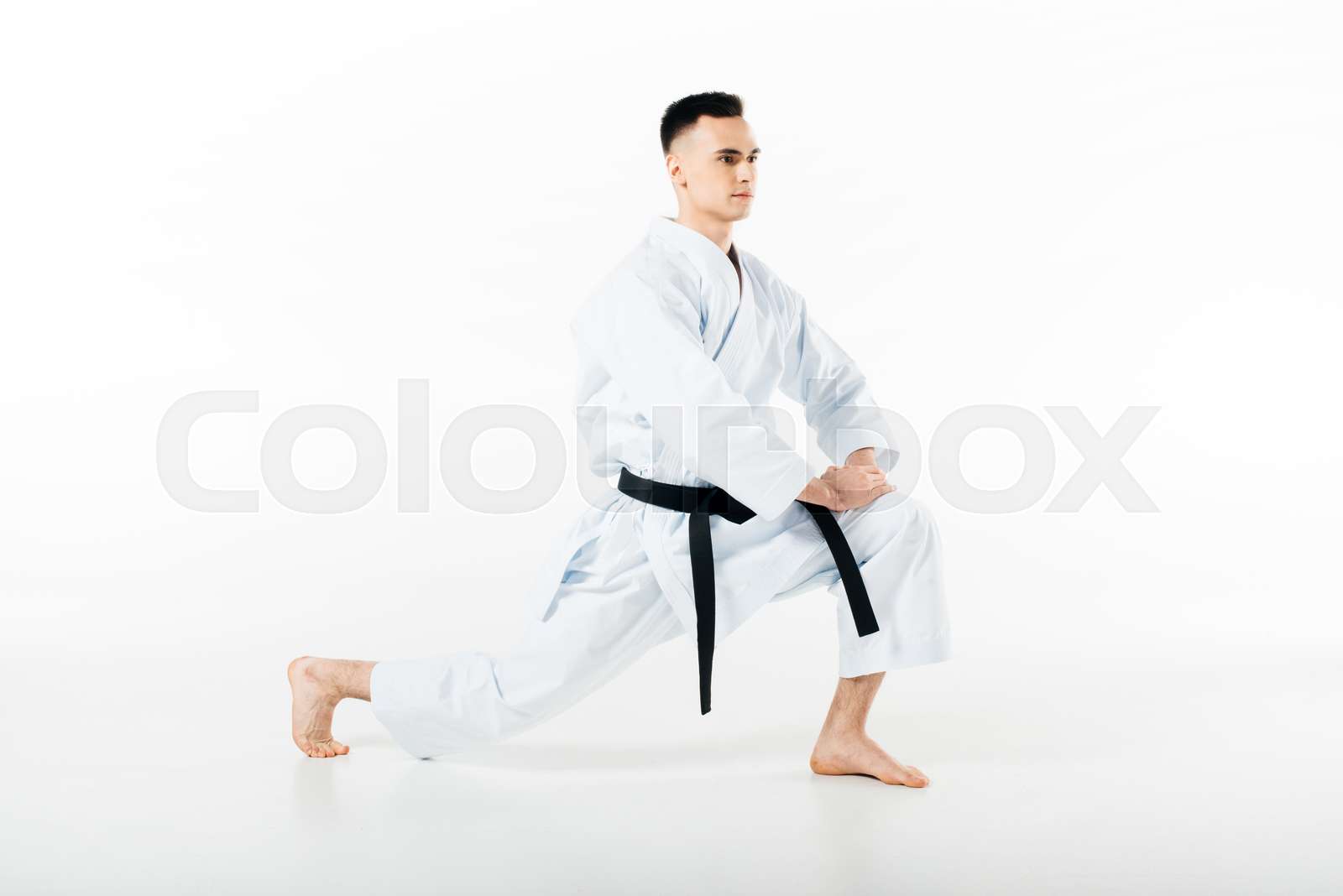 male karate fighter stretching legs isolated on white | Stock image ...