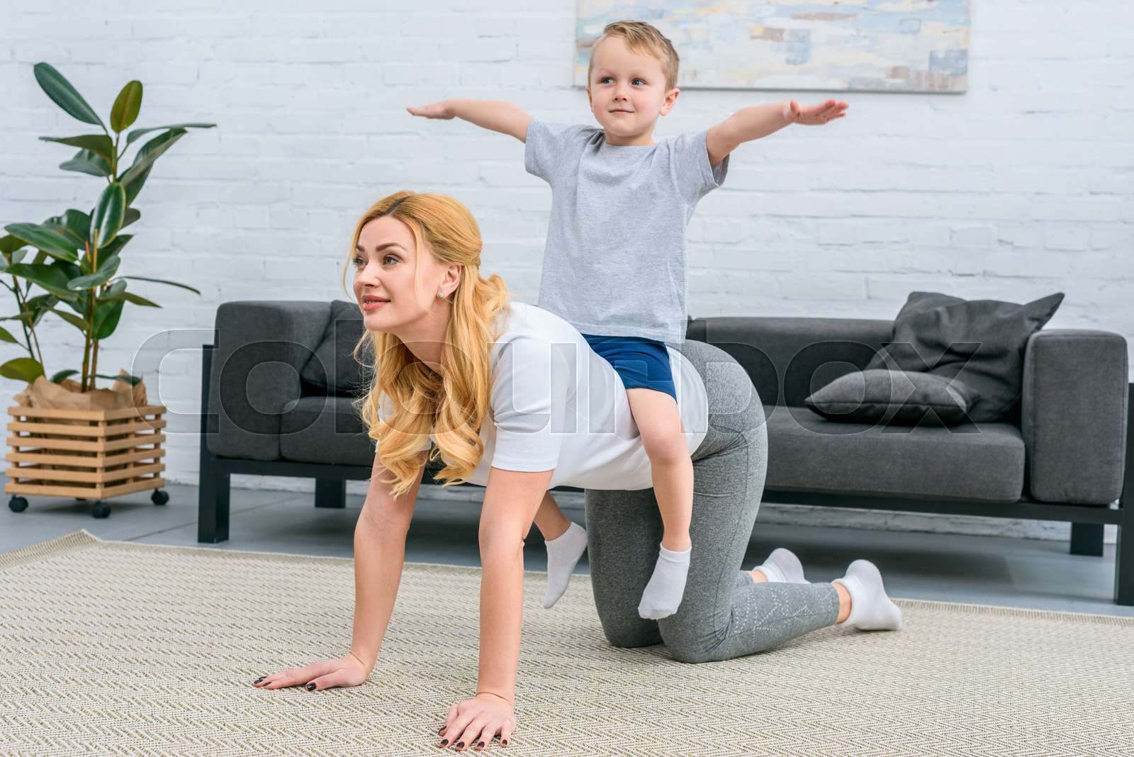 Mother standing on all fours with little son on back | Stock image ...
