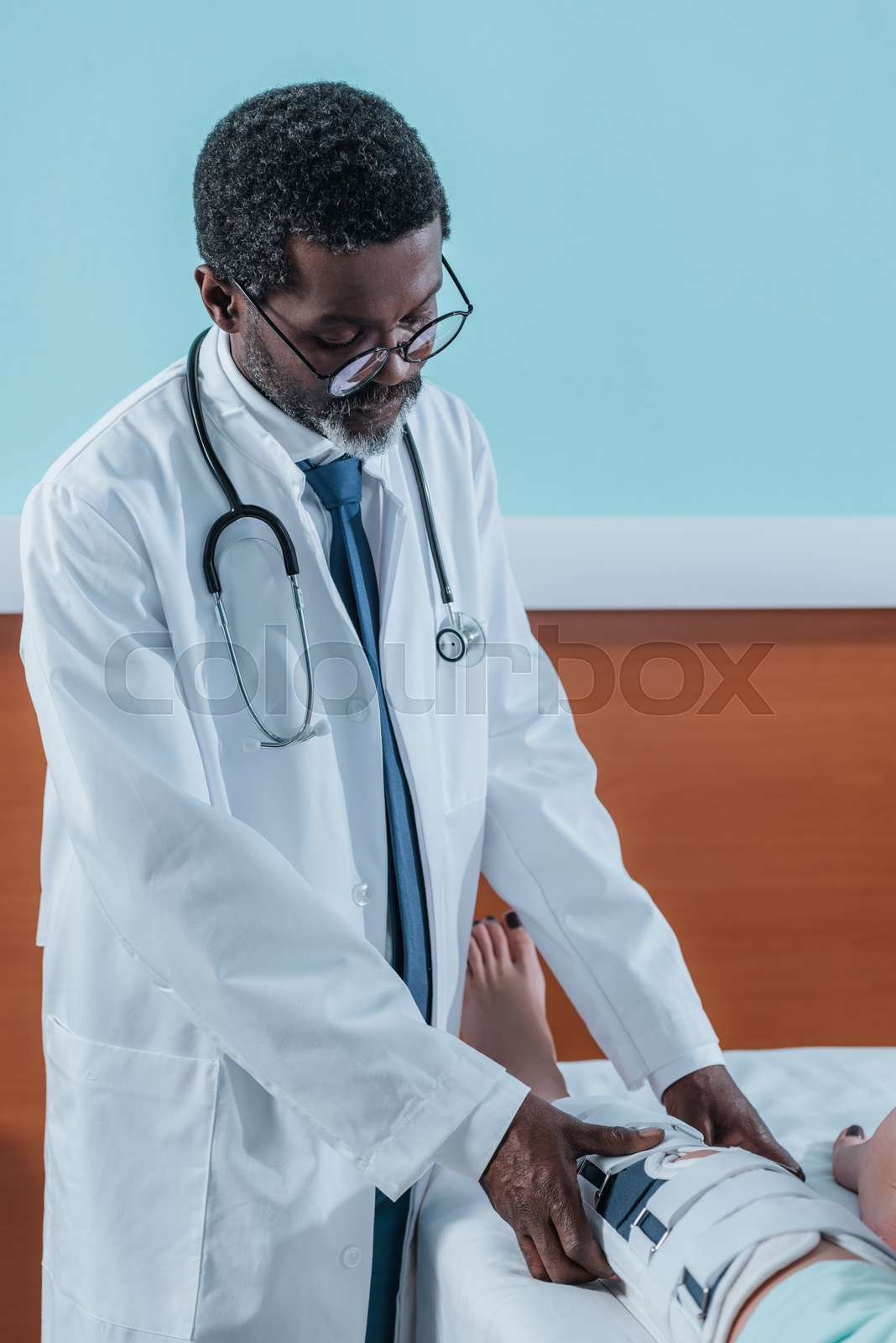 doctor putting on leg brace | Stock image | Colourbox