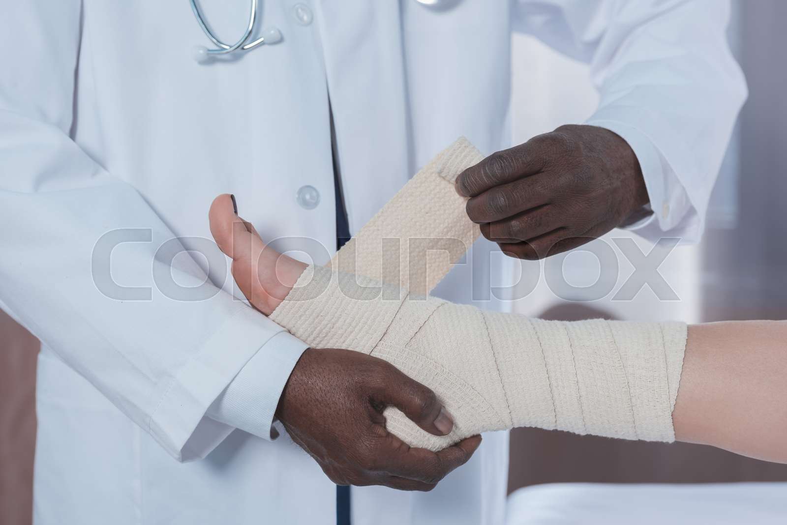 doctor bandaging patient leg | Stock image | Colourbox