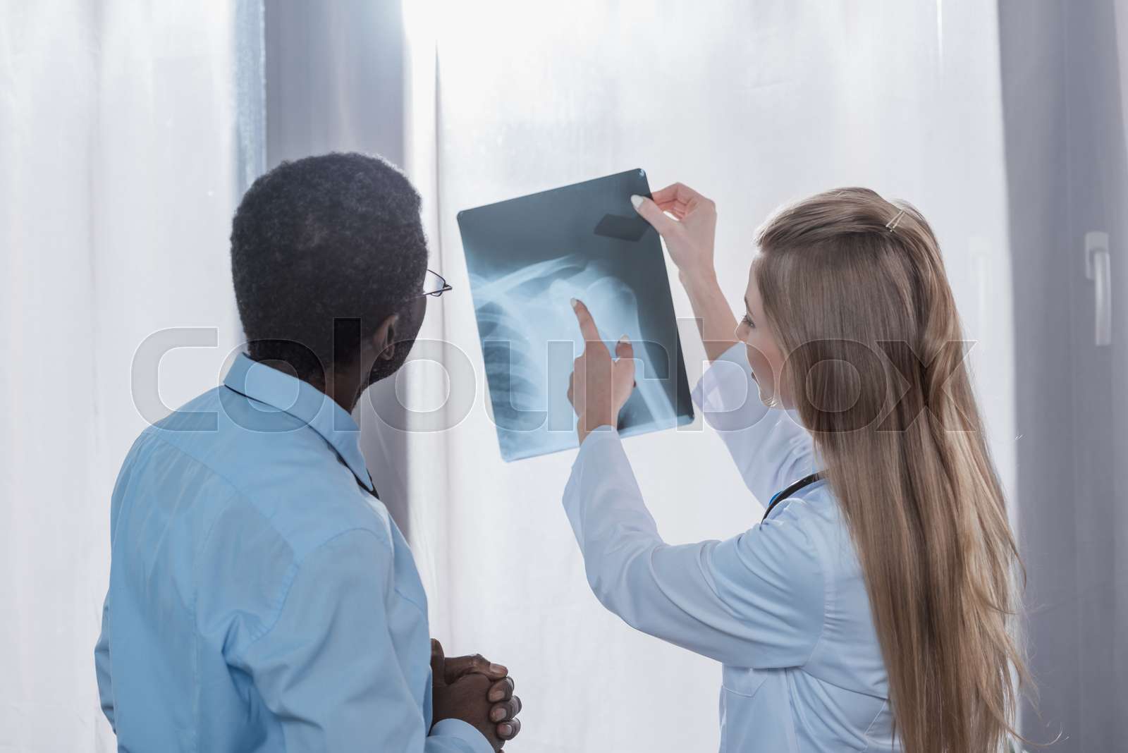 Doctor showing x-ray to patient | Stock image | Colourbox