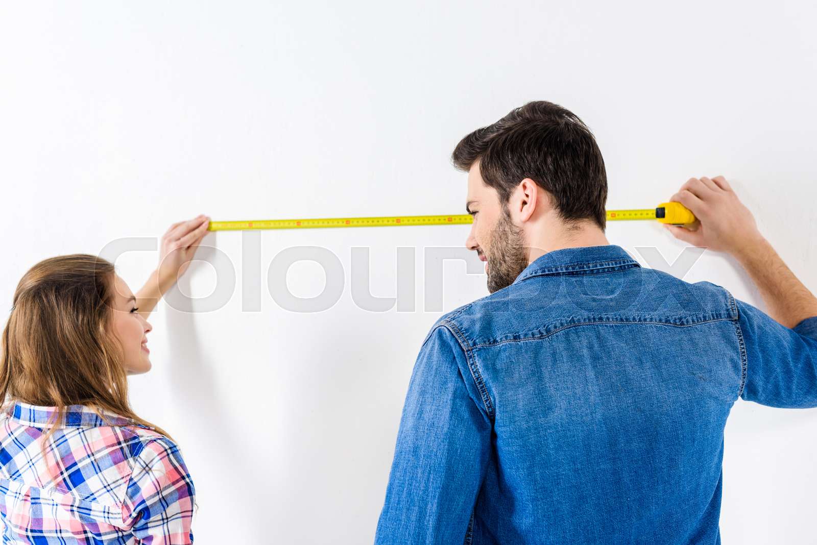 girlfriend and boyfriend measuring wall with tape measure | Stock image ...