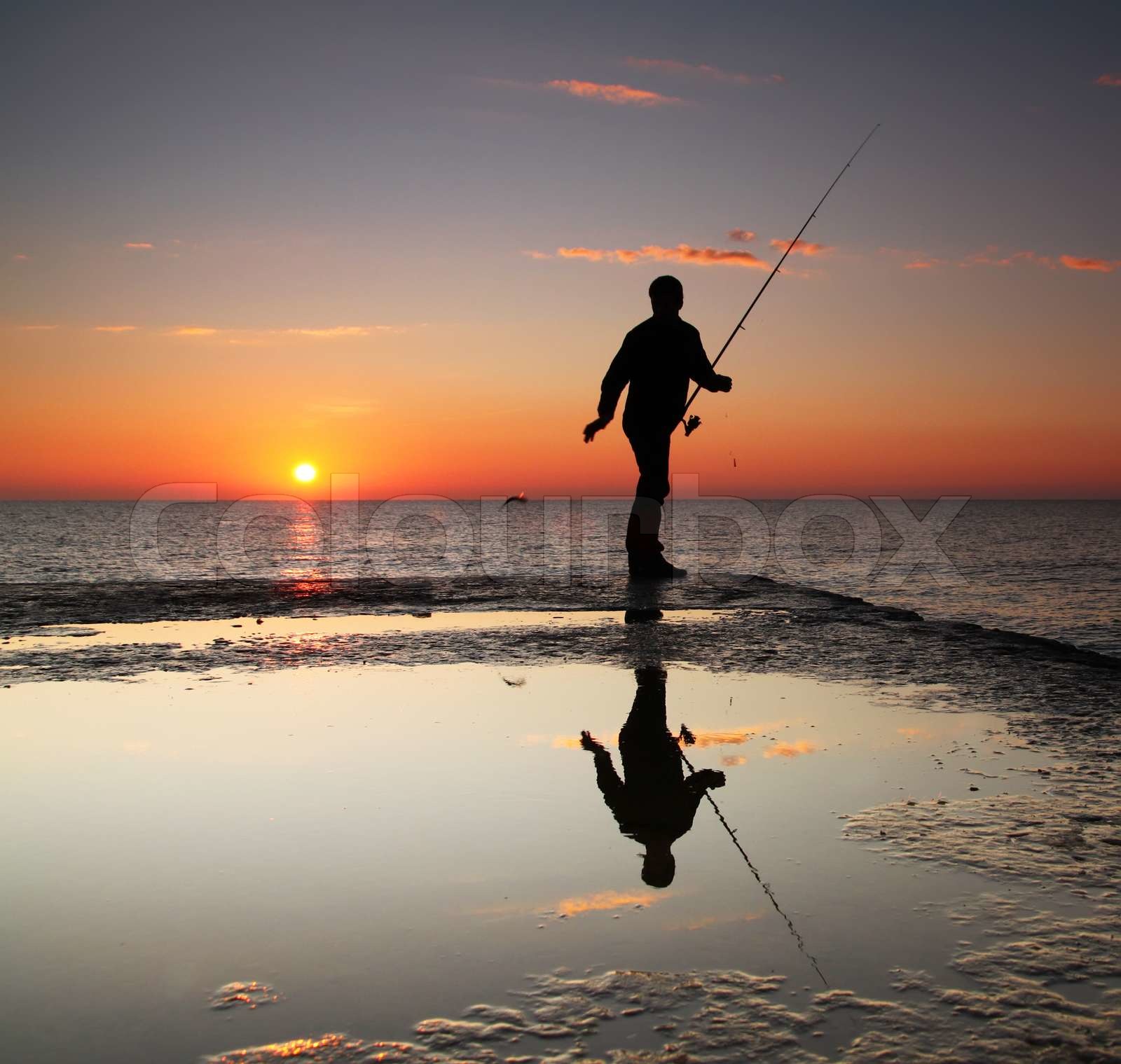 Fisherman at sunrise on the sea | Stock image | Colourbox