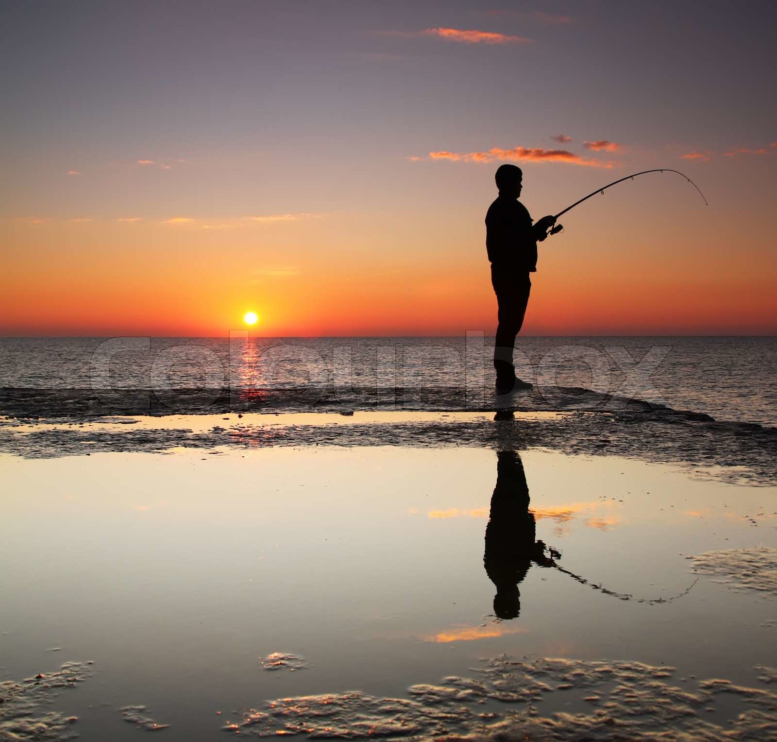 Fisherman at sunrise on the sea | Stock image | Colourbox