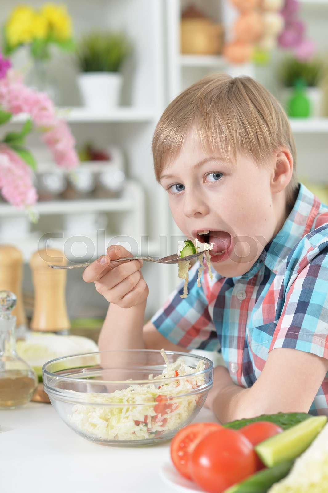 Cute boy eating healthy salad | Stock image | Colourbox