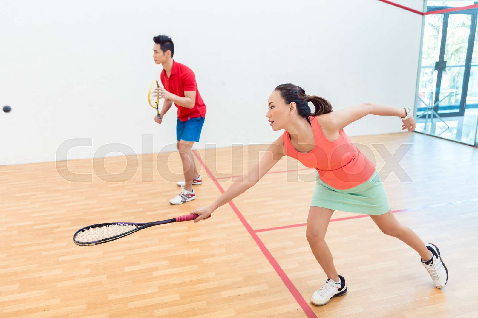 Competitive Chinese woman holding the racquet during a squash game ...
