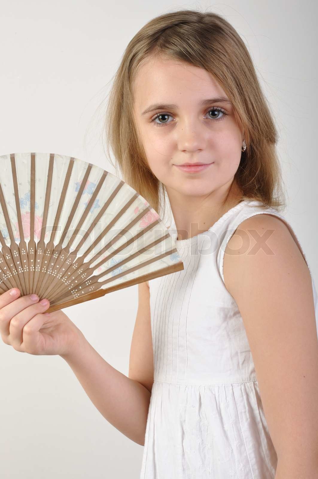 portrait of a beautiful elementary age girl fanning herself | Stock ...