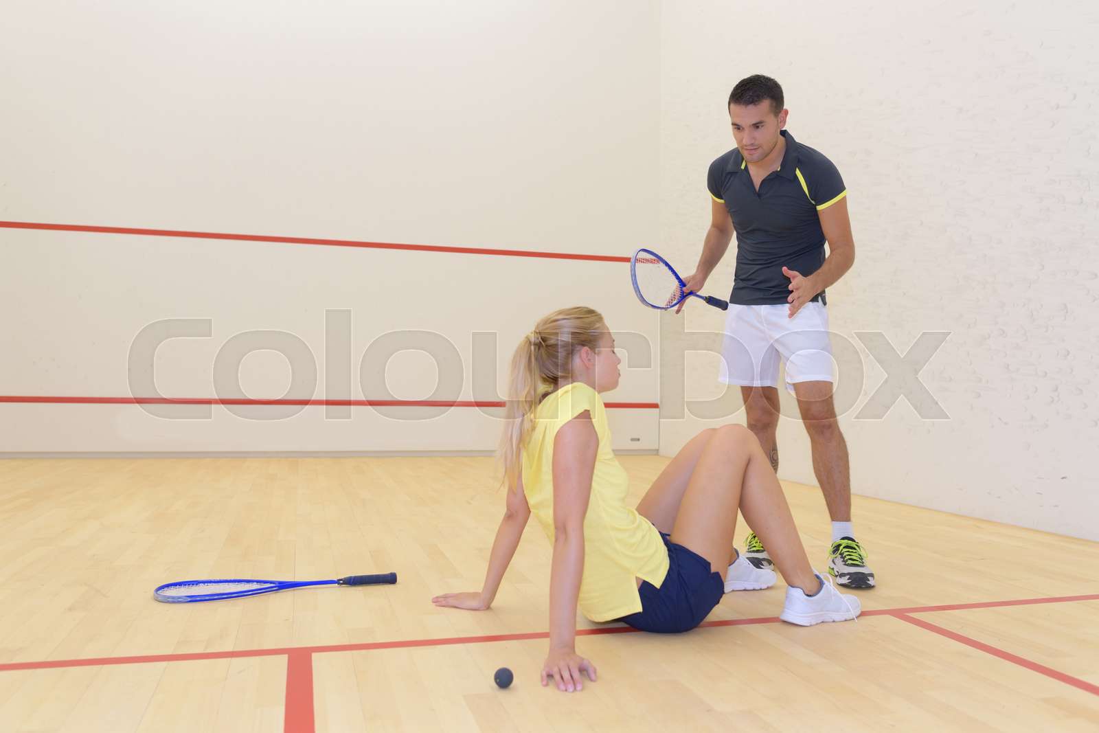 couple in squash court woman sat on floor | Stock image | Colourbox