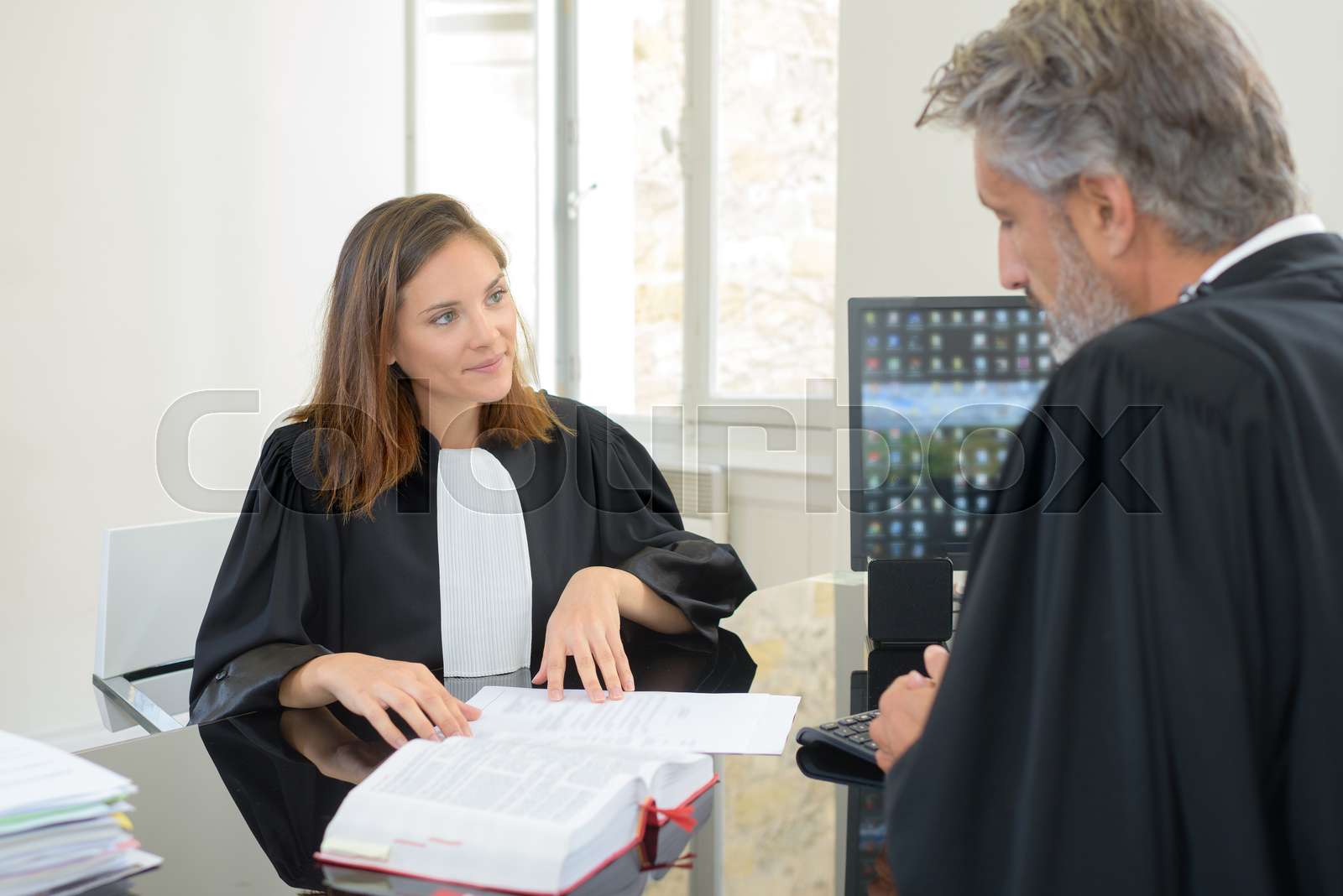 Judges in robes looking at hardback book | Stock image | Colourbox