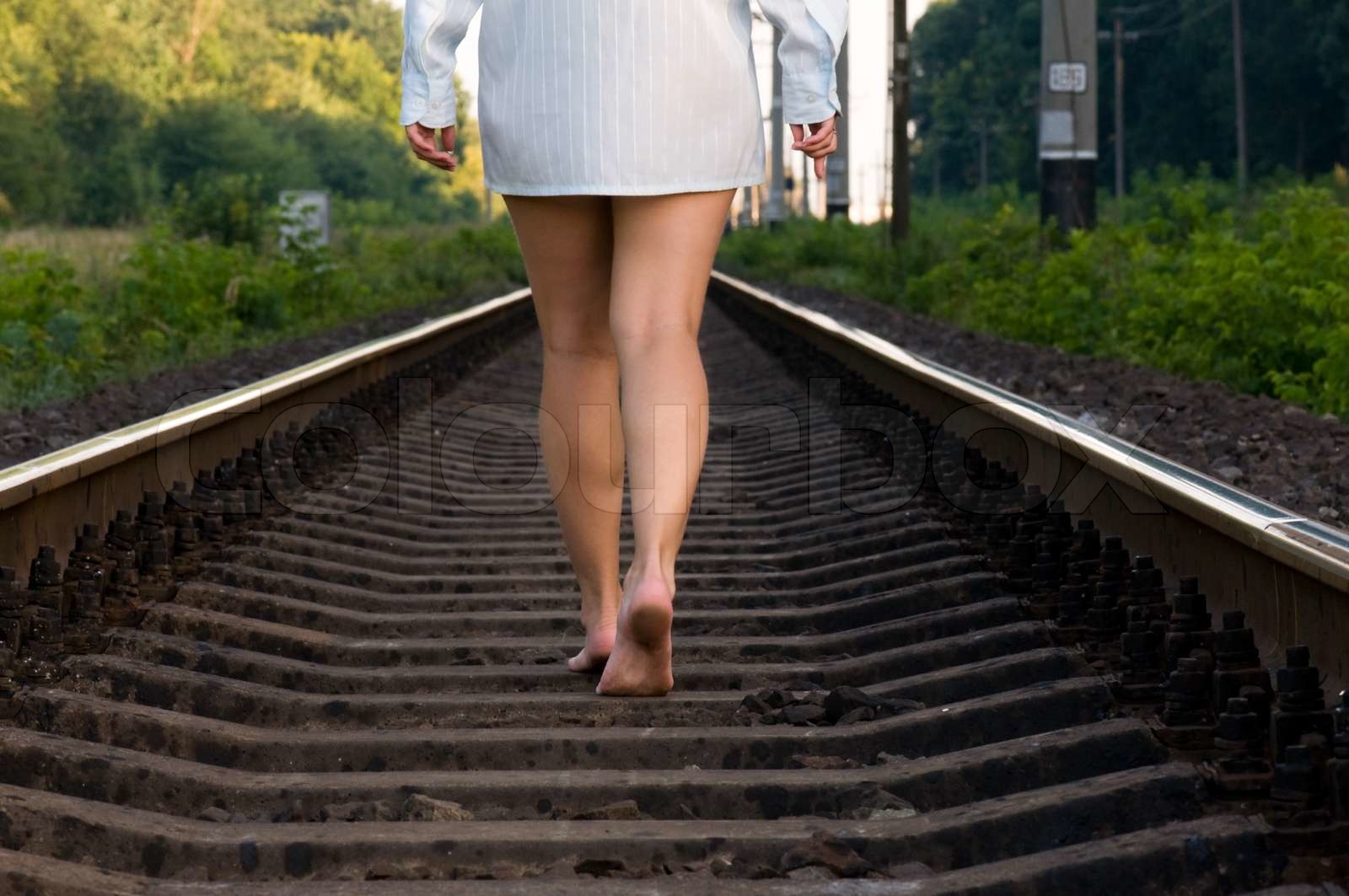 Young beautiful woman walking on a railroad track | Stock image | Colourbox