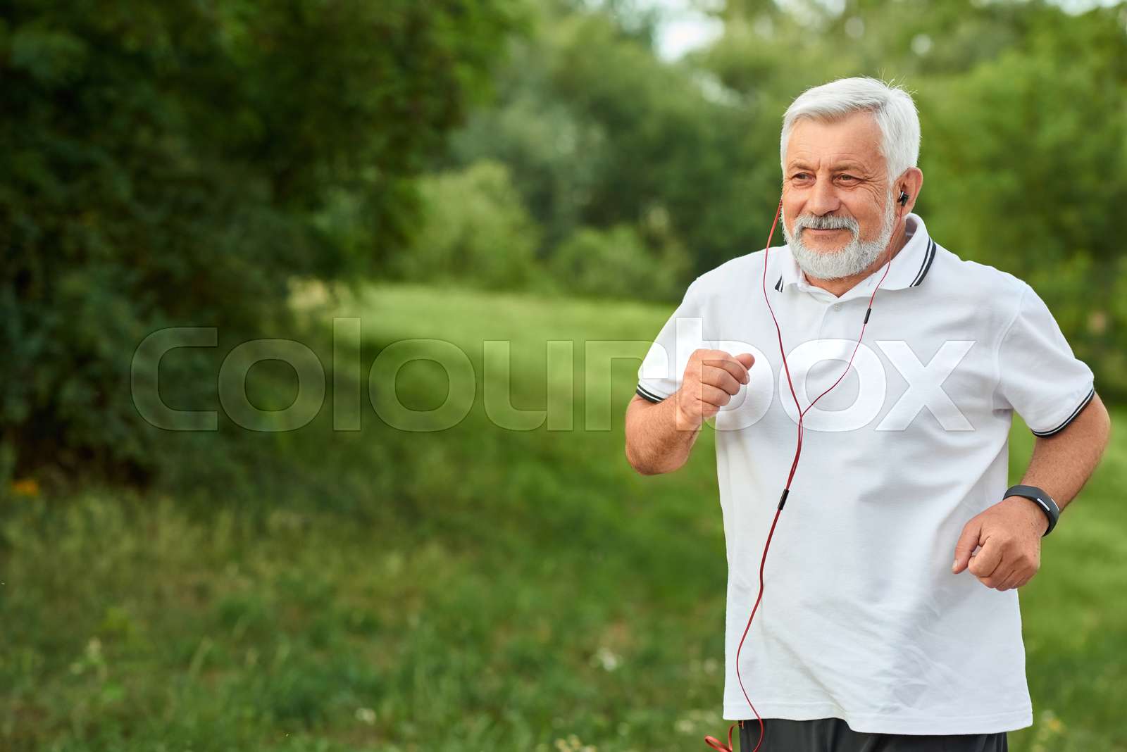 Smiling running old man in green city park. | Stock image | Colourbox