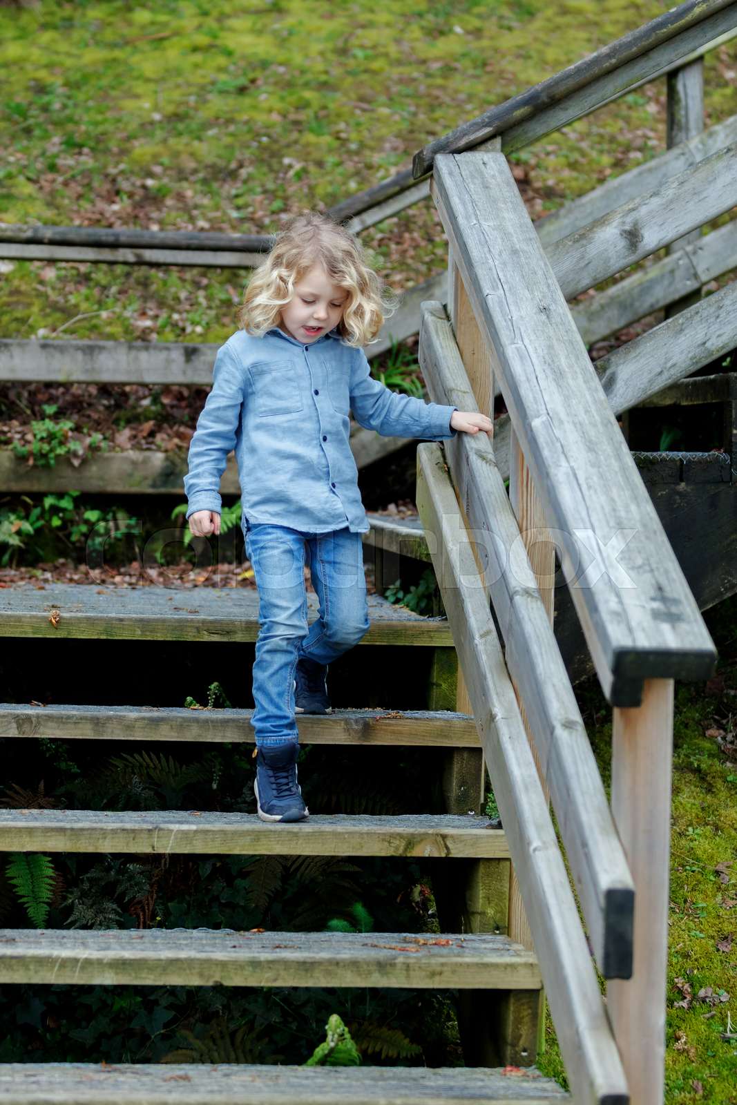 Happy kid going down wooden stairs | Stock image | Colourbox