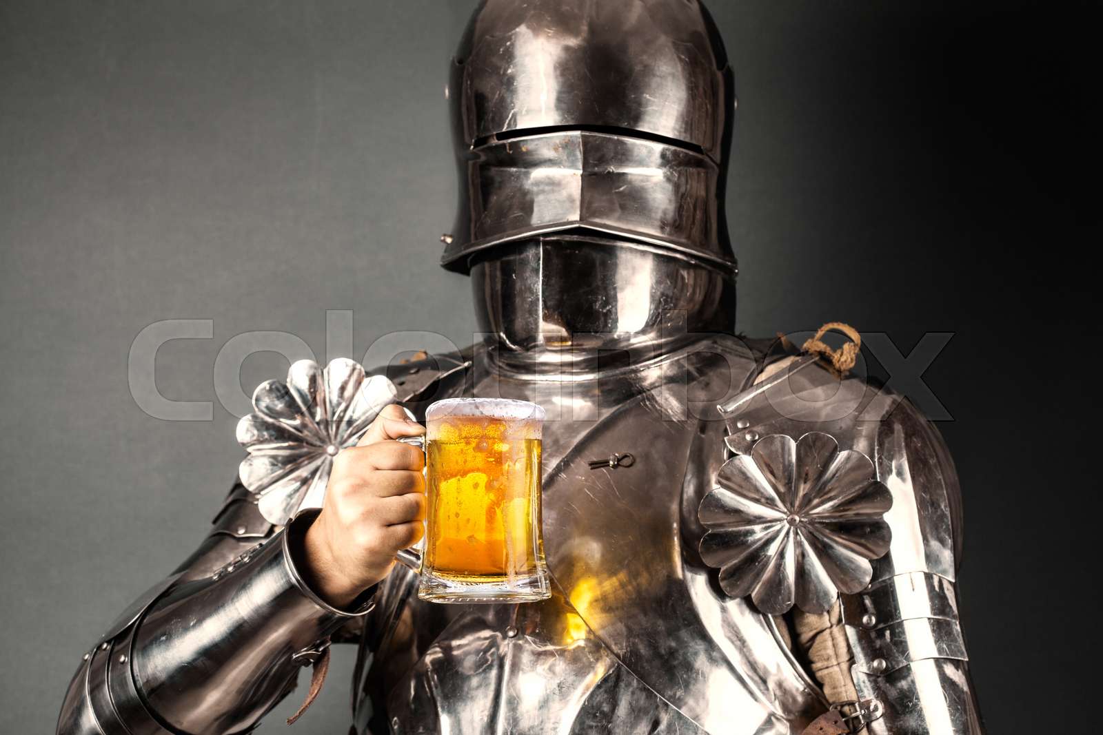 knight wearing armor and holding mug of beer | Stock image | Colourbox