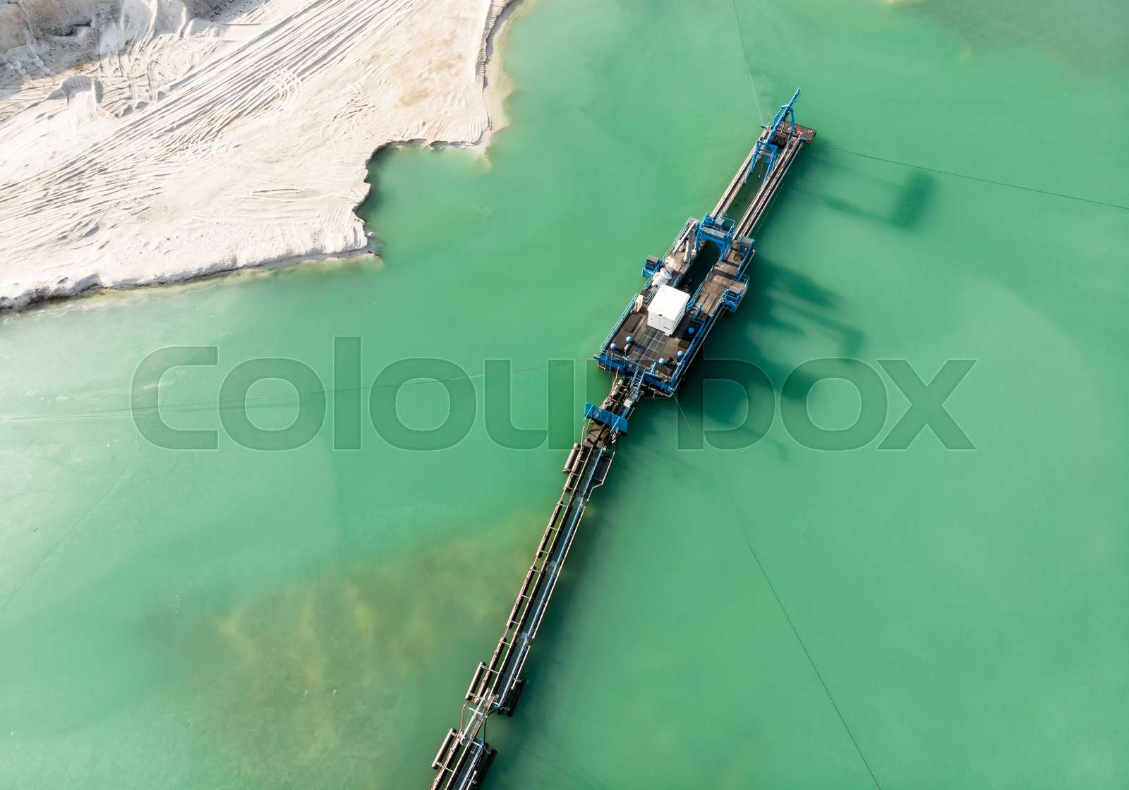 Aerial view of the long boom of a suction excavator in a quartz quarry ...