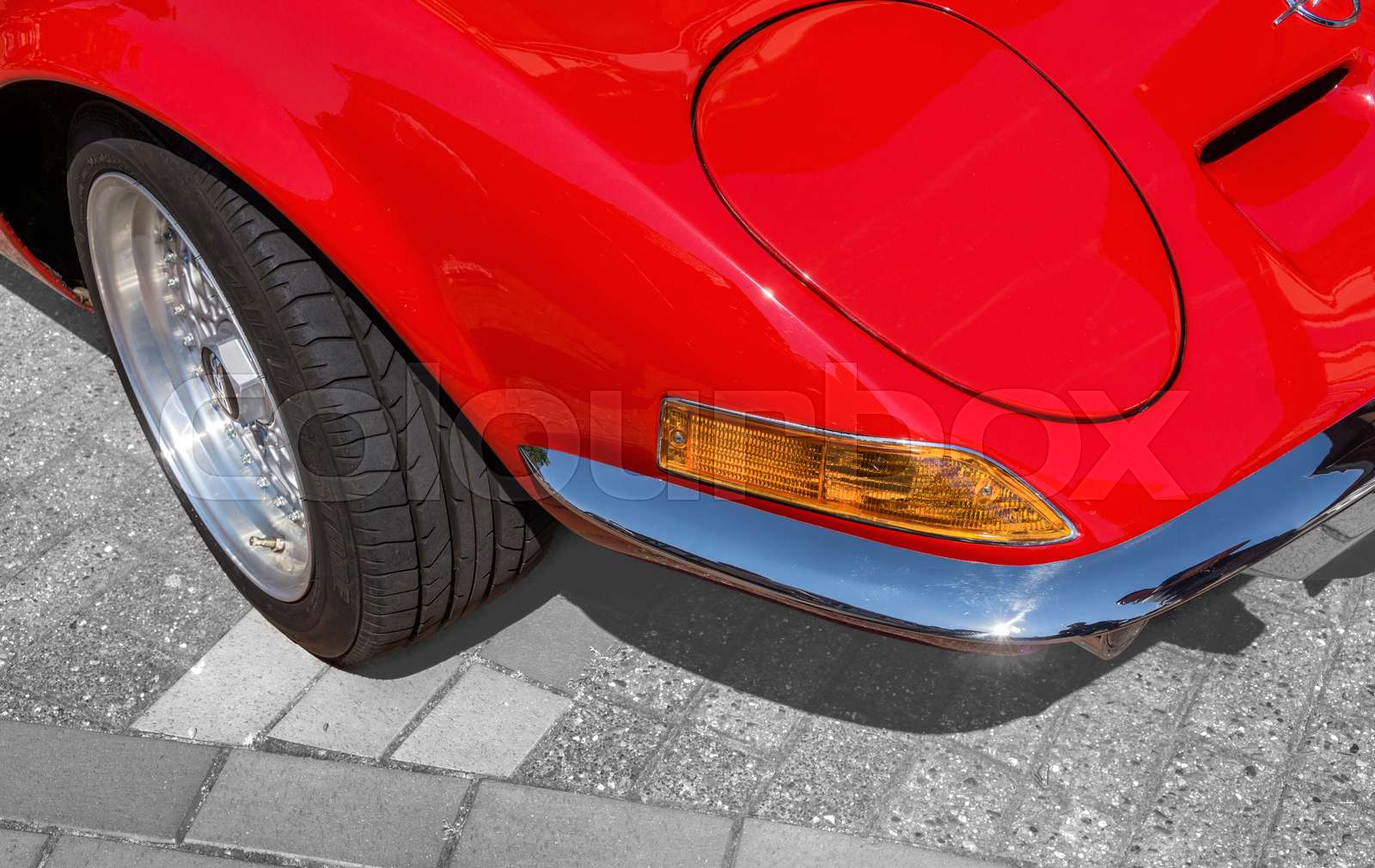 Detail view, from the right front corner of a red sports car with ...