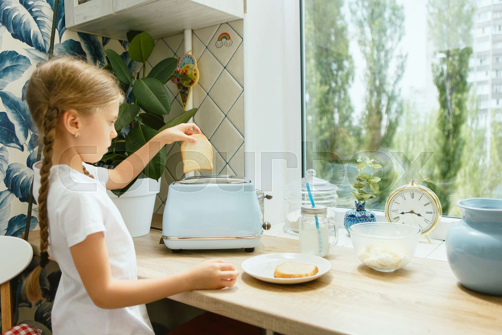 Beautiful girl in her kitchen in the morning preparing breakfast ...