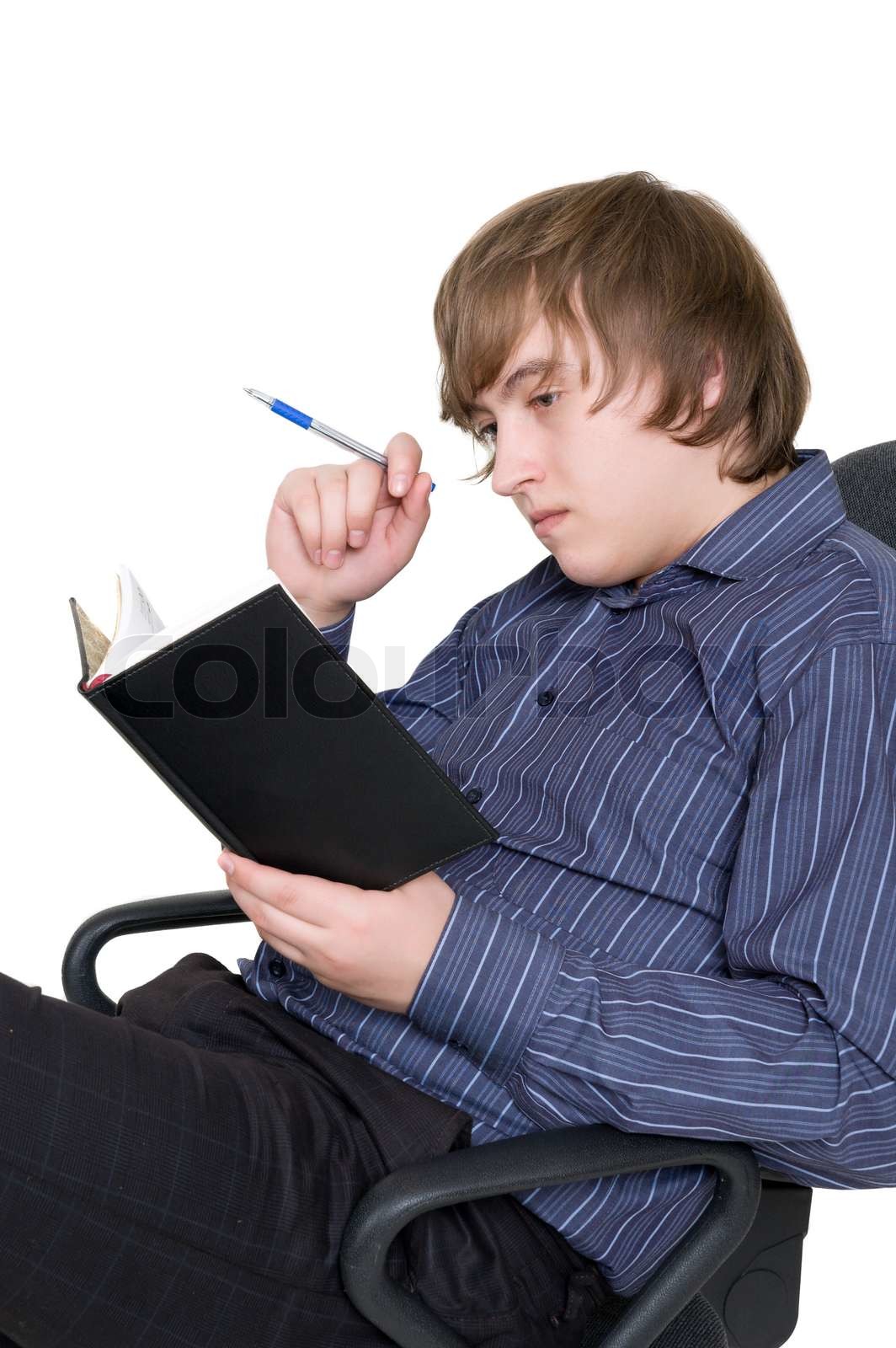 young man with with pen and notebook in a chair | Stock image | Colourbox