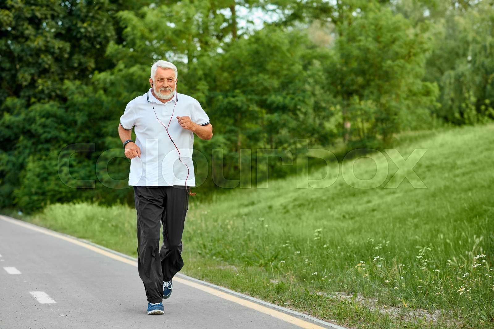 Old man running on modern city park's racetrack. | Stock image | Colourbox