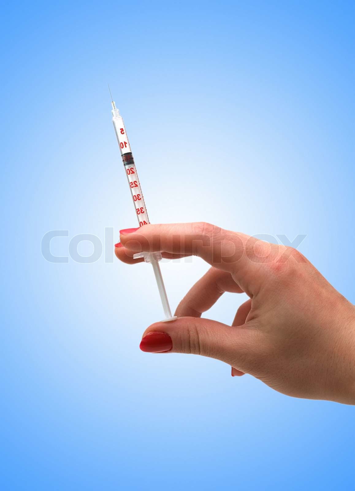 Hand holding syringe isolated on the white | Stock image | Colourbox