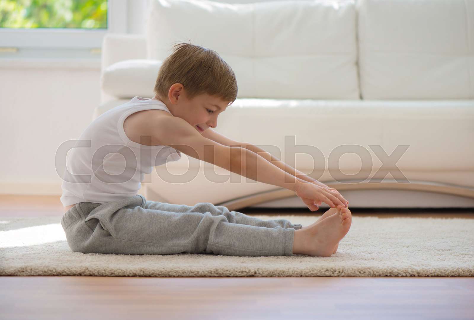 Happy little boy exercising at home | Stock image | Colourbox