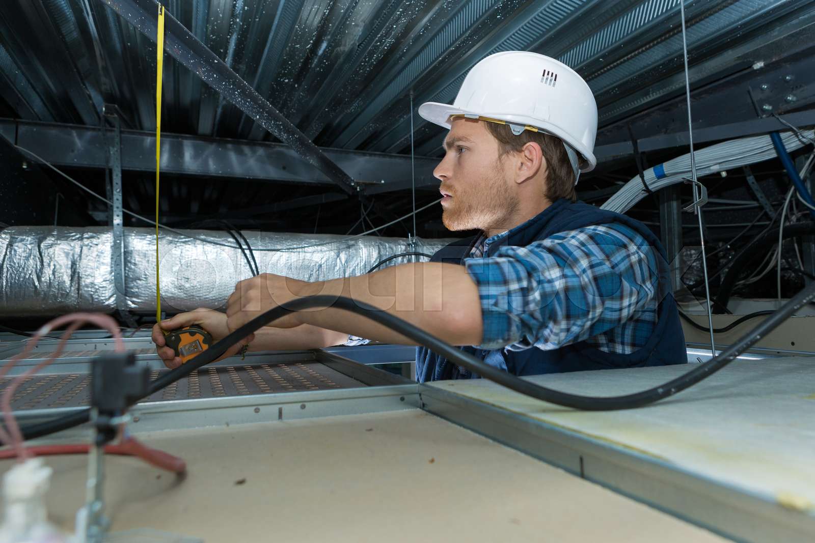 electrical worker wiring in ceiling | Stock image | Colourbox