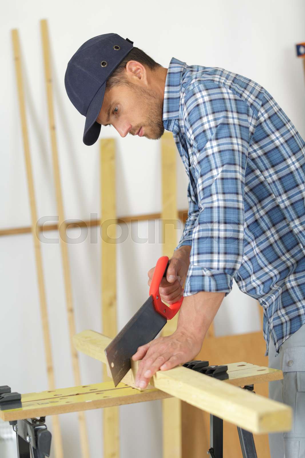 man cutting wood with a hand saw | Stock image | Colourbox