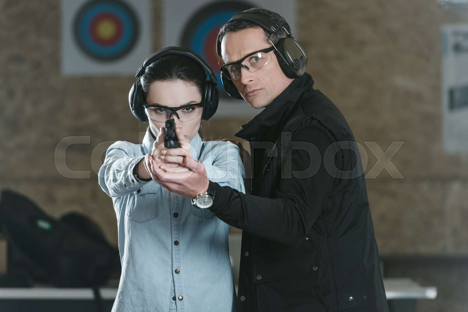 female customer aiming gun at camera in shooting gallery | Stock image ...