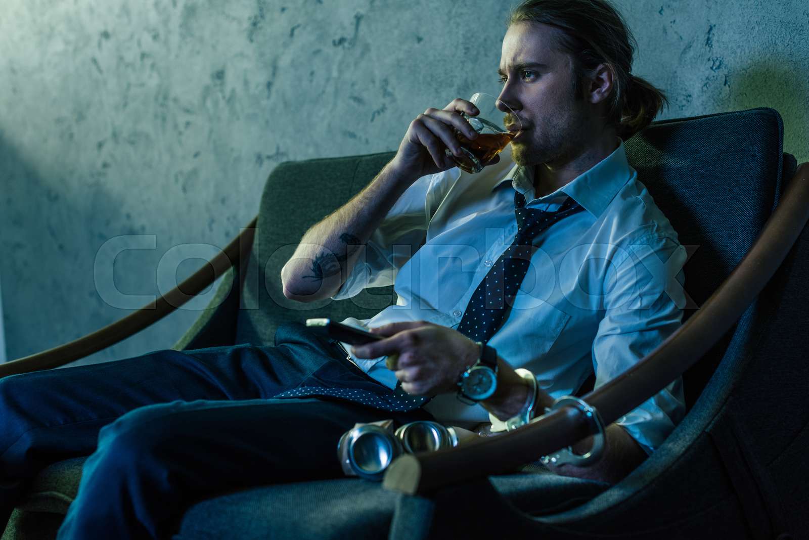 alcohol addicted man in white shirt watching tv and drinking whiskey ...