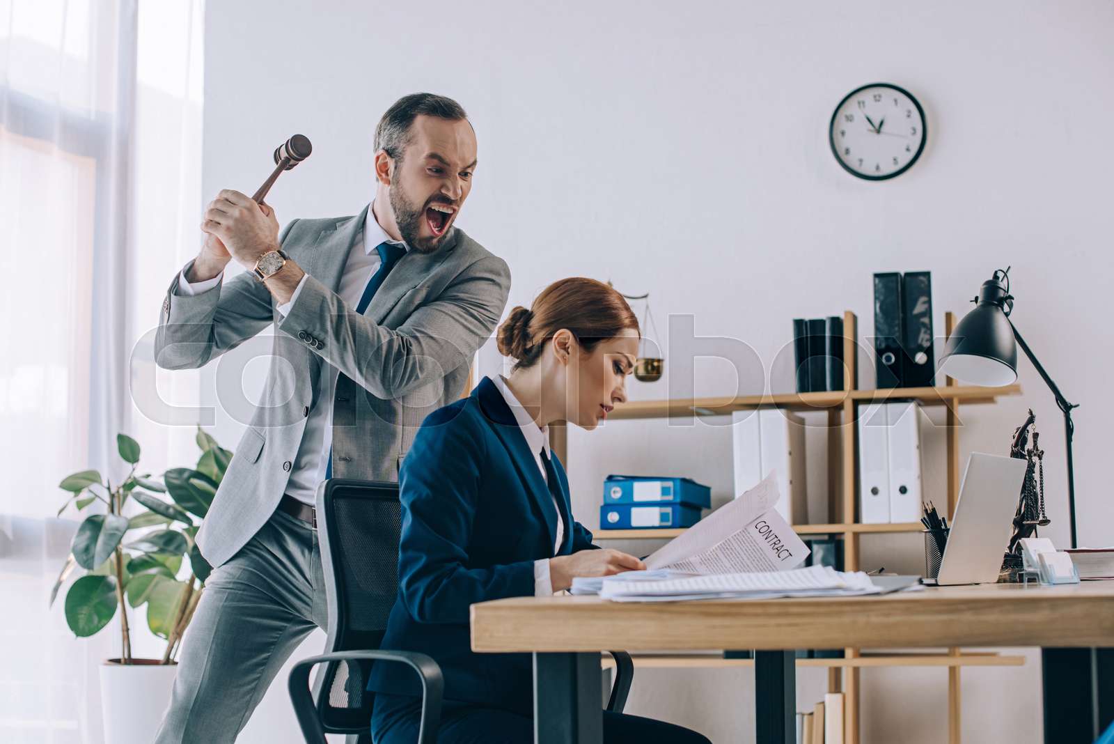 angry lawyer pretending to hit colleague with gavel in hands in office ...