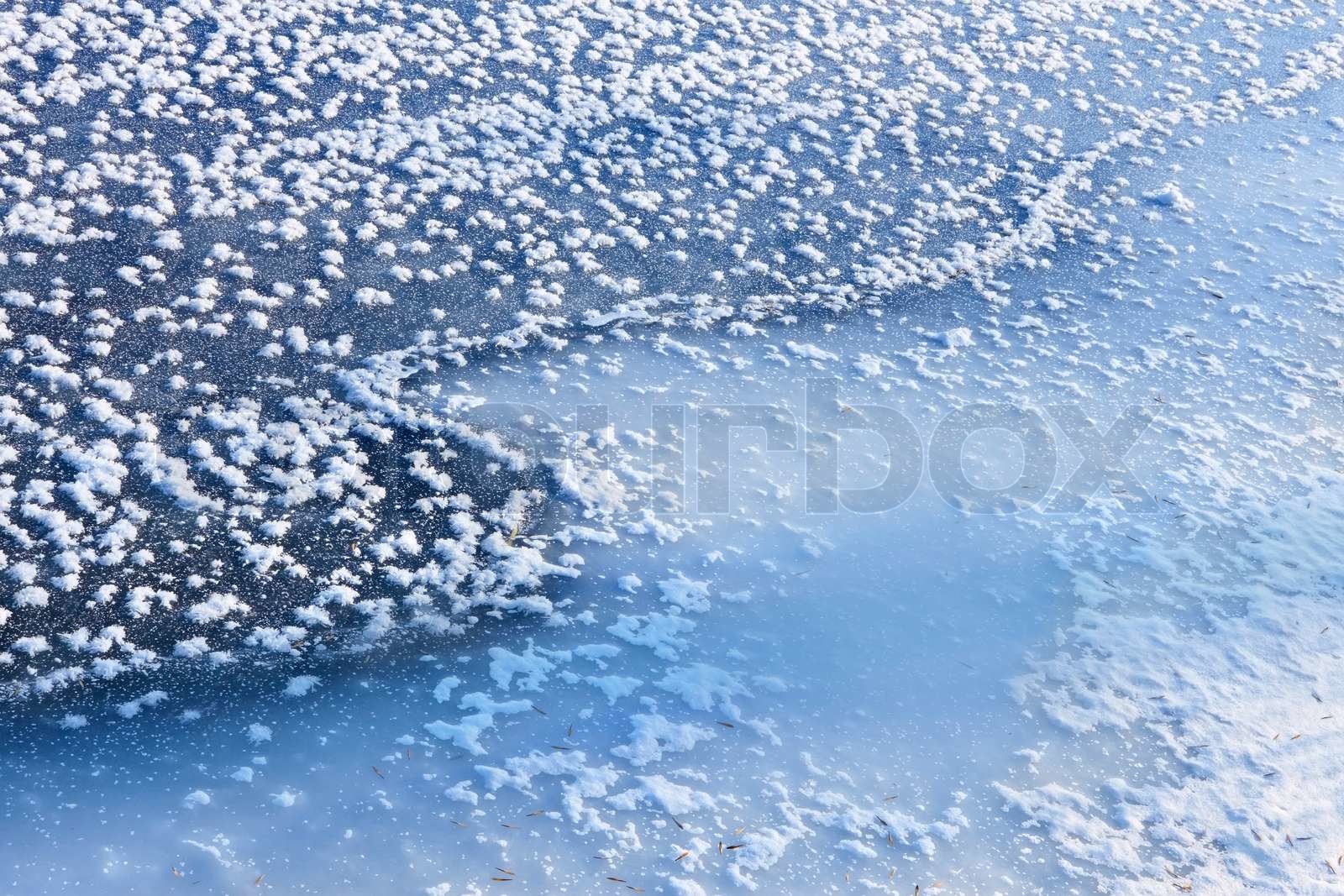 Frozen river surface with the rime as a randomly placed snowflakes ...