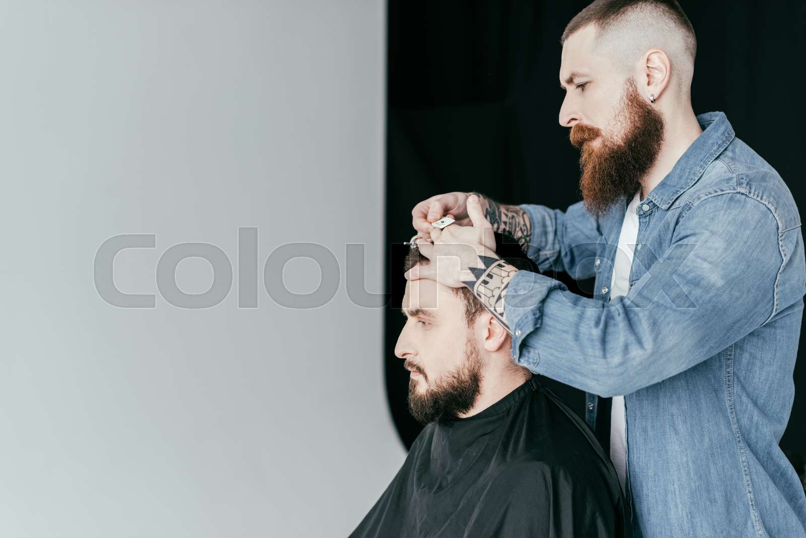 side view of barber cutting customer hair at barbershop | Stock image ...