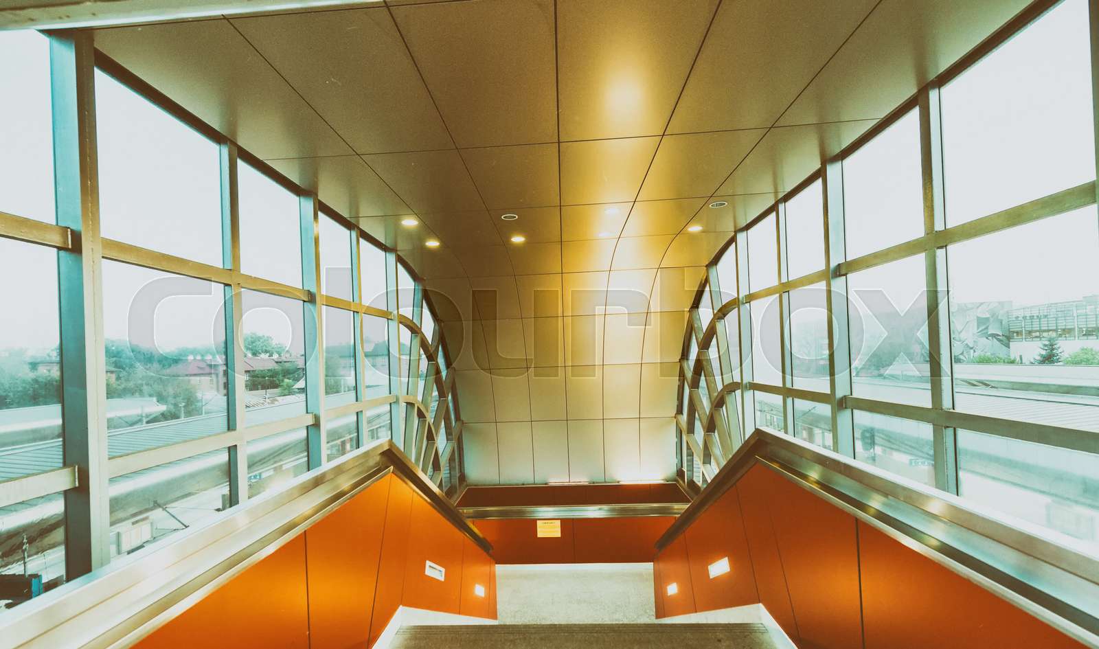 Modern corridor with staircase surrounded by glass windows | Stock ...