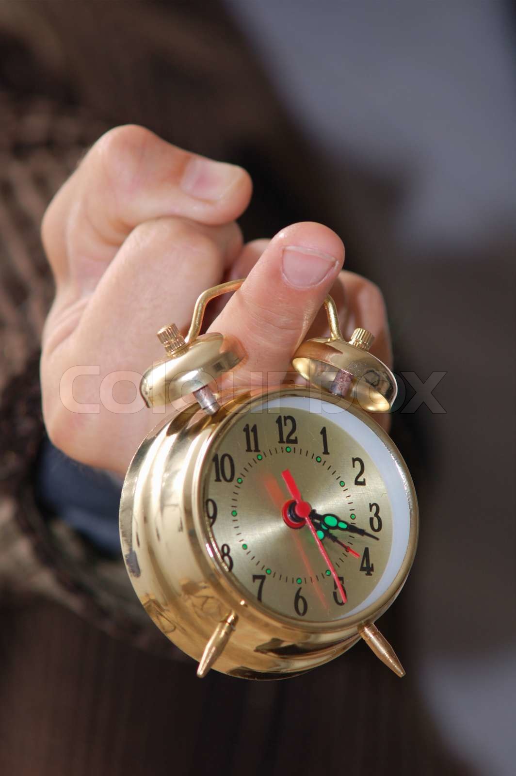 A man keeping an alarm clock on his finger | Stock image | Colourbox