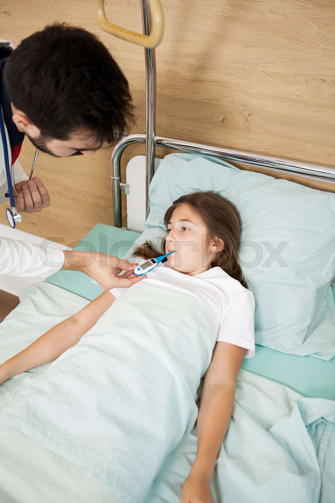 Doctor taking body temperature of her patient | Stock image | Colourbox