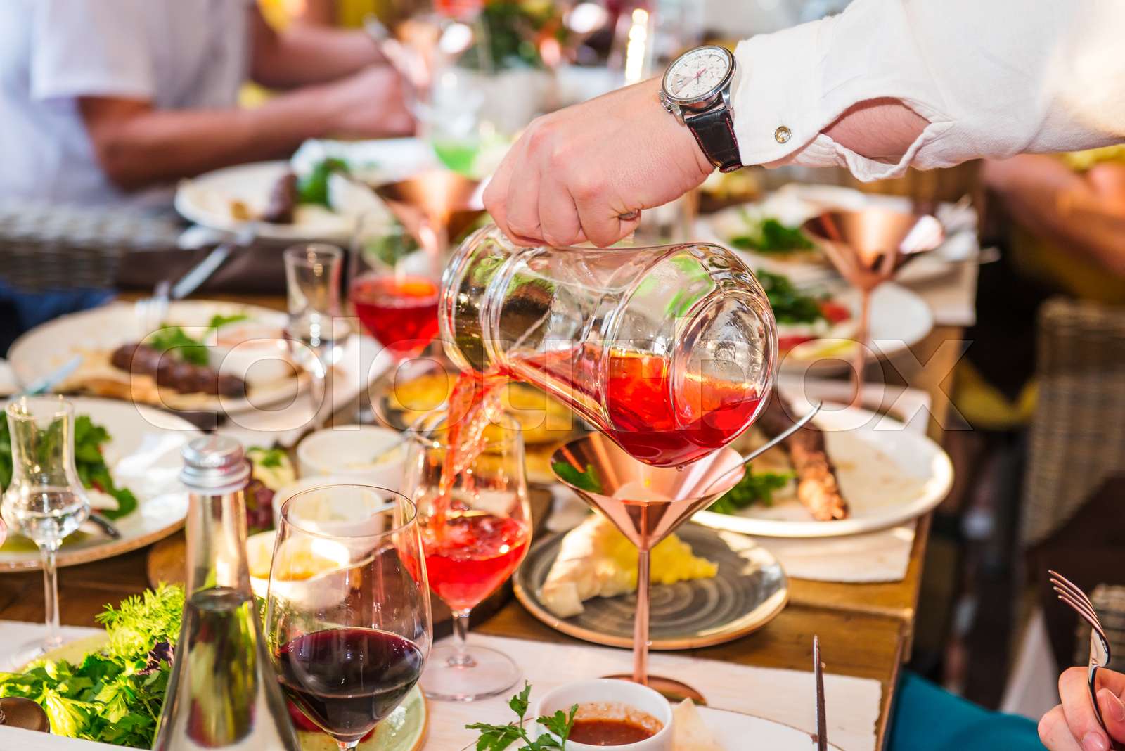 Professional waiter in uniform serving drinks to guests of event ...